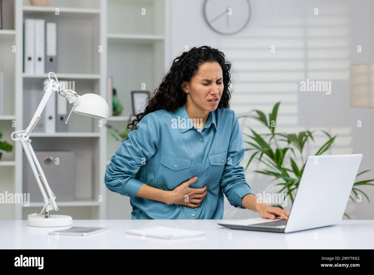 Person experiencing stomach discomfort seated hi-res stock photography ...
