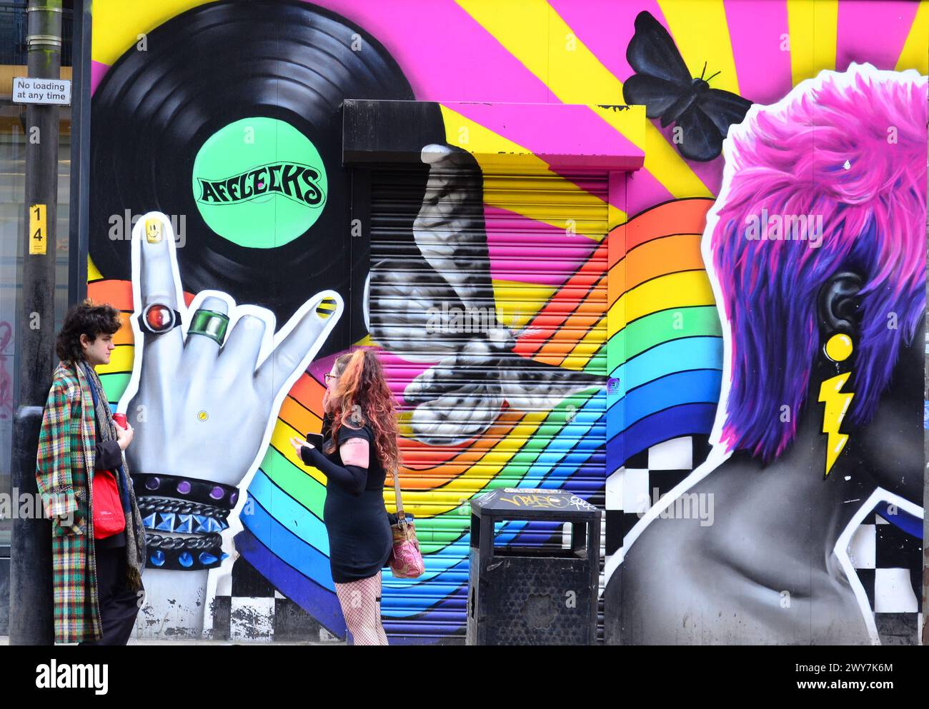Two people talk in front of artwork on an outside wall of Affleck's ...