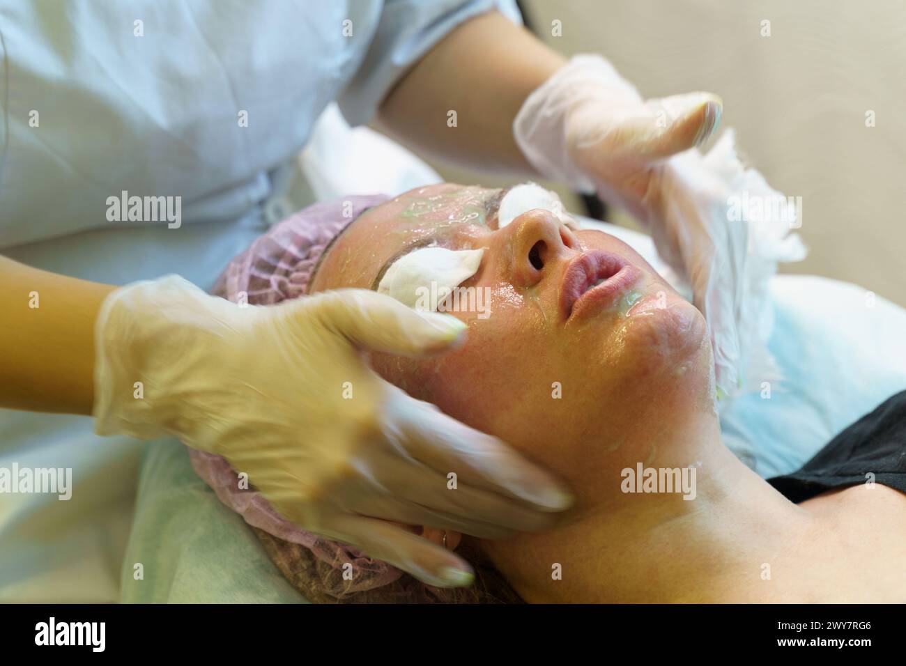 A woman getting a facial mask applied to her face at a spa or skincare ...