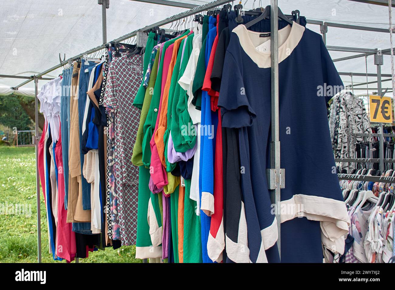 Clothes hanging on the hangers of a stall at the Coia urban market in ...