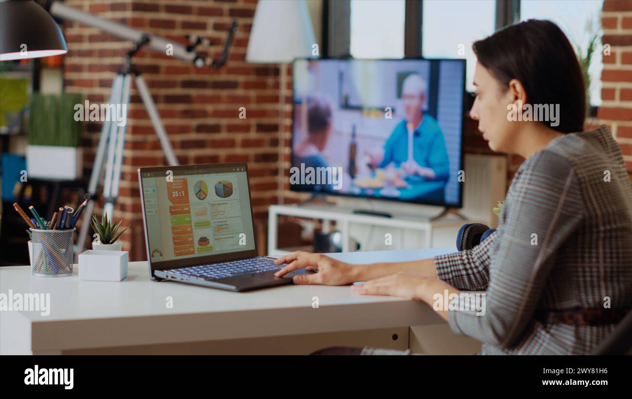 Remote employee optimizing market performance charts with tv as ...