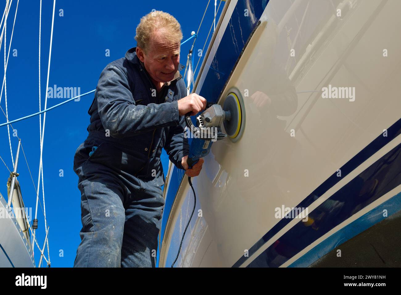 Yacht owner polishing the glass fibre hull on his Hallberg Rassy 36 ...