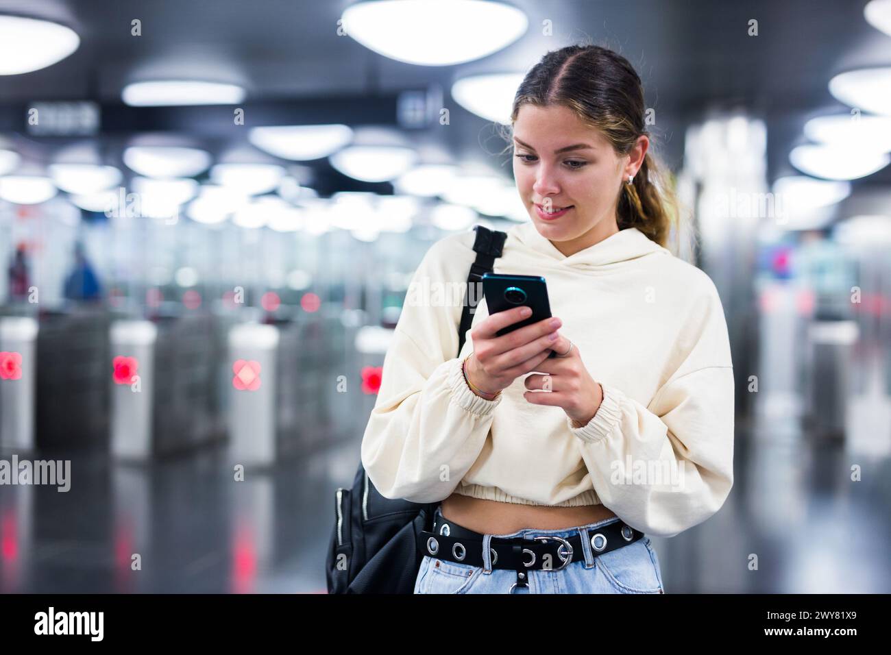 Positive girl with a mobile phone entered the subway, passing through ...