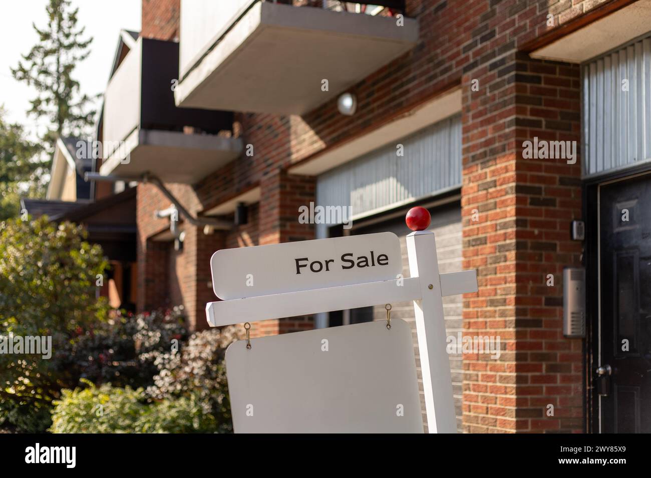 For sale sign in front of a condo house in a residential neighborhood ...