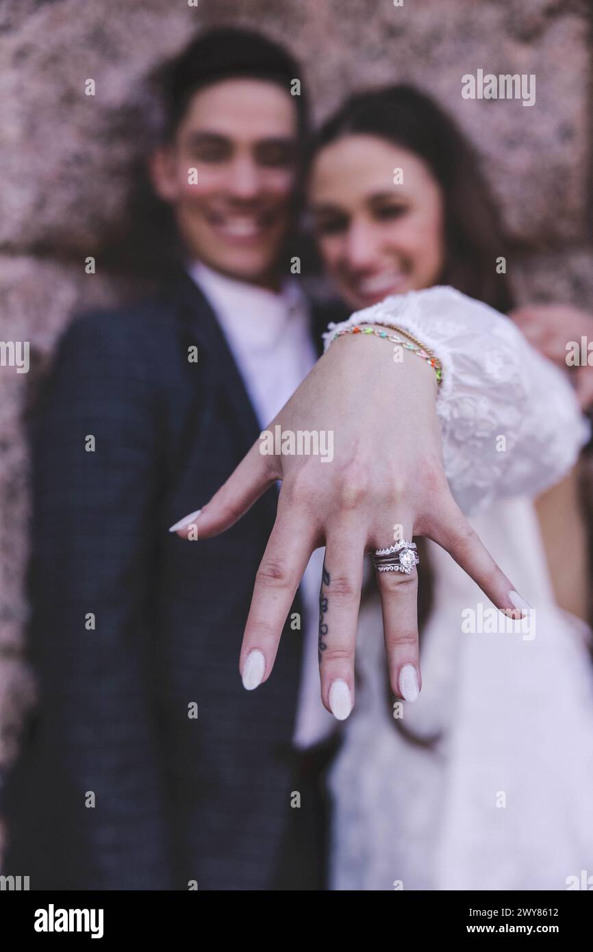 Newlywed couple's hands showcasing wedding rings, focus on the symbol ...