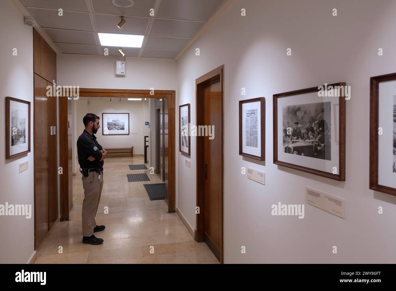 A security guard looks at old photos displayed at the Jewish Agency for ...