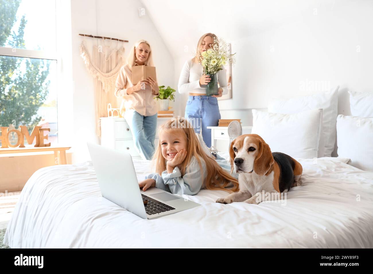 Cute little girl with dog watching cartoons in bedroom Stock Photo - Alamy
