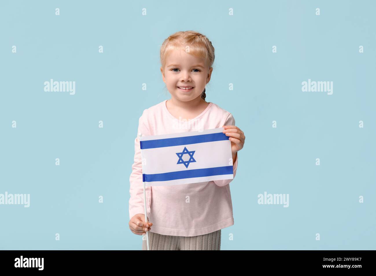 Cute happy little girl with Israel flag on blue background. Hanukkah ...
