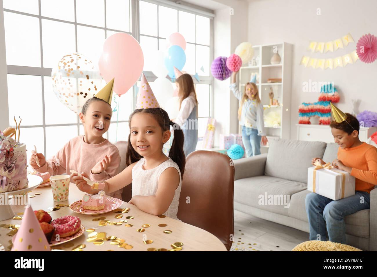 Cute little girls eating Birthday cake at party Stock Photo - Alamy
