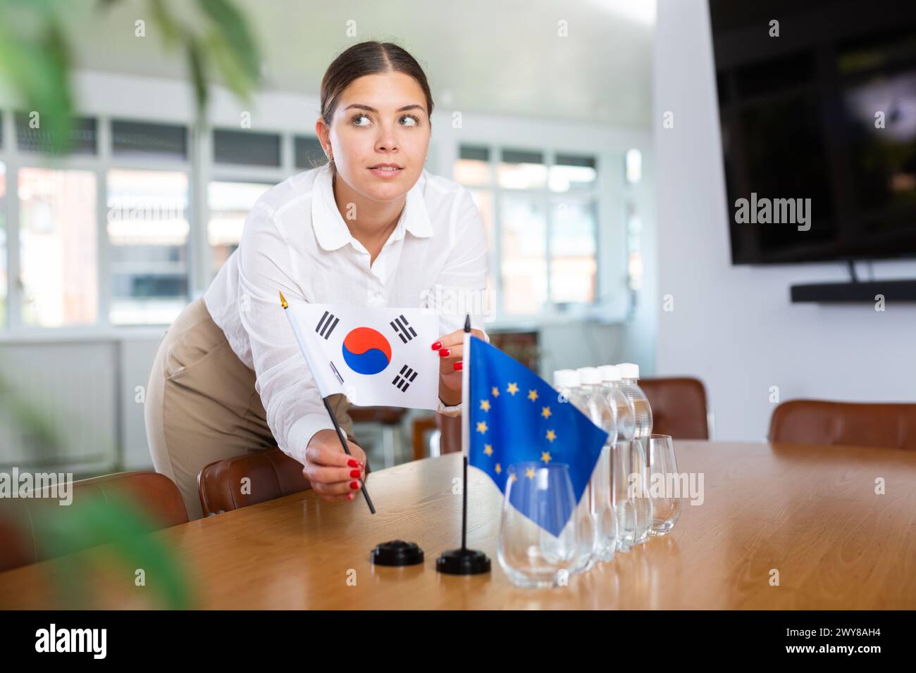 Female secretary places flags of the European Union and South Korea ...