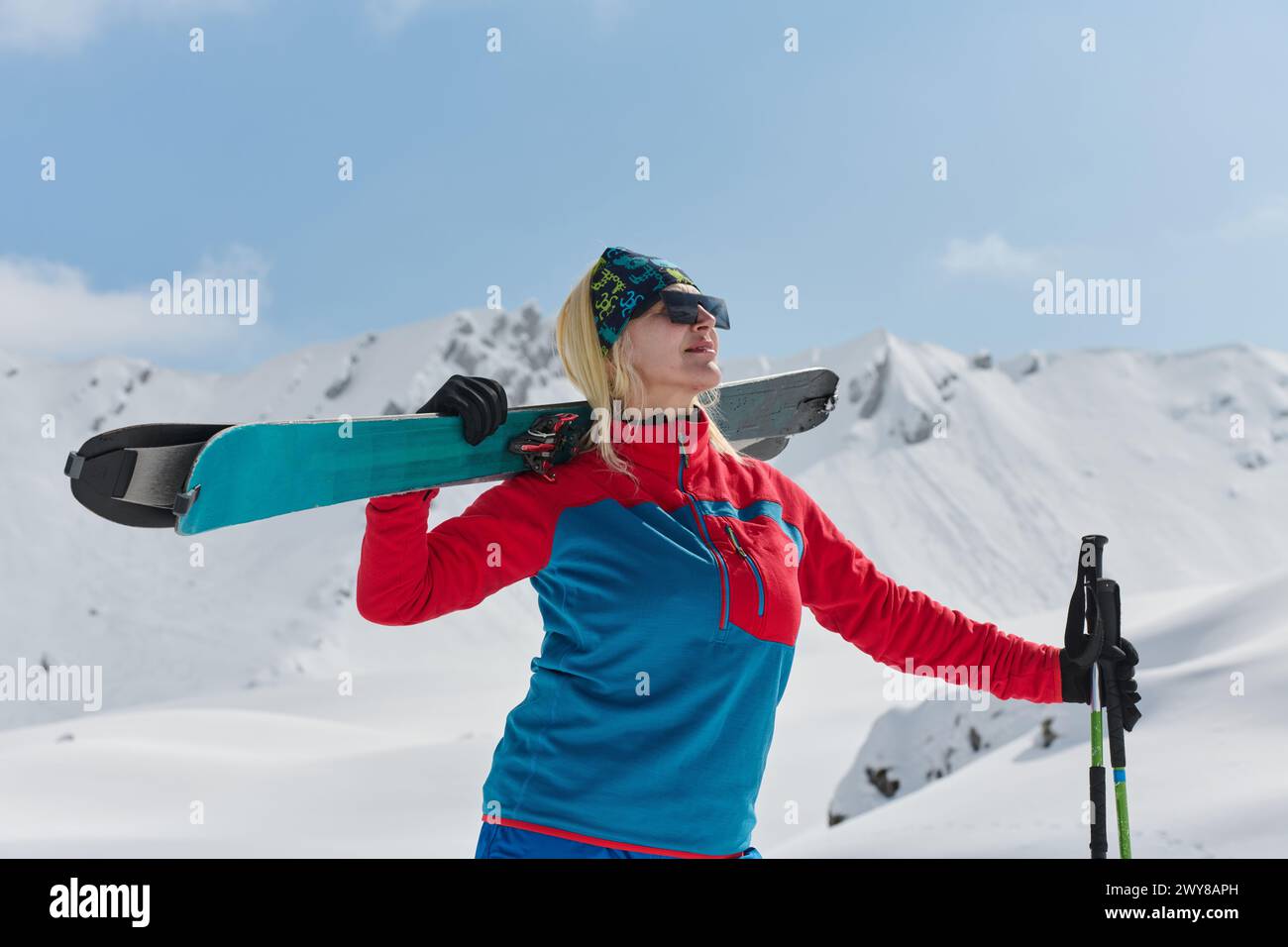 A professional woman skier rejoices after successfully climbing the ...