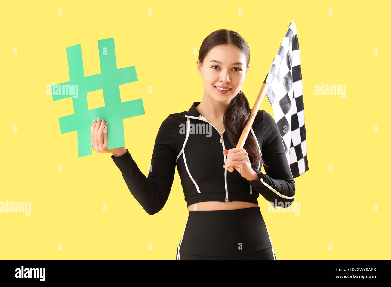 Beautiful grid girl with racing flag and hashtag sign on yellow ...