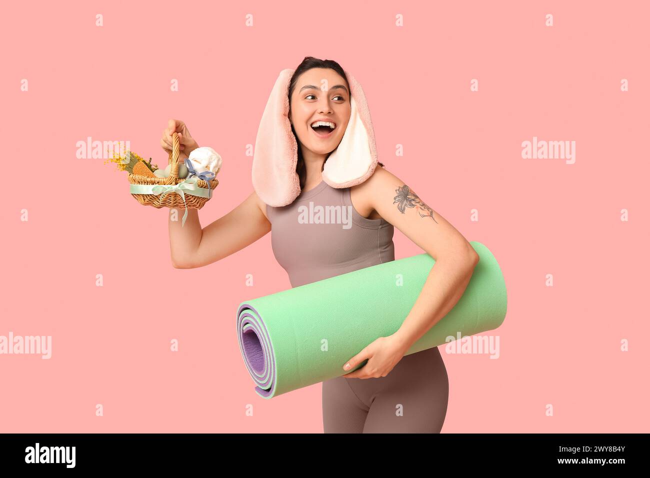 Happy female fitness coach in bunny ears with Easter basket and yoga ...