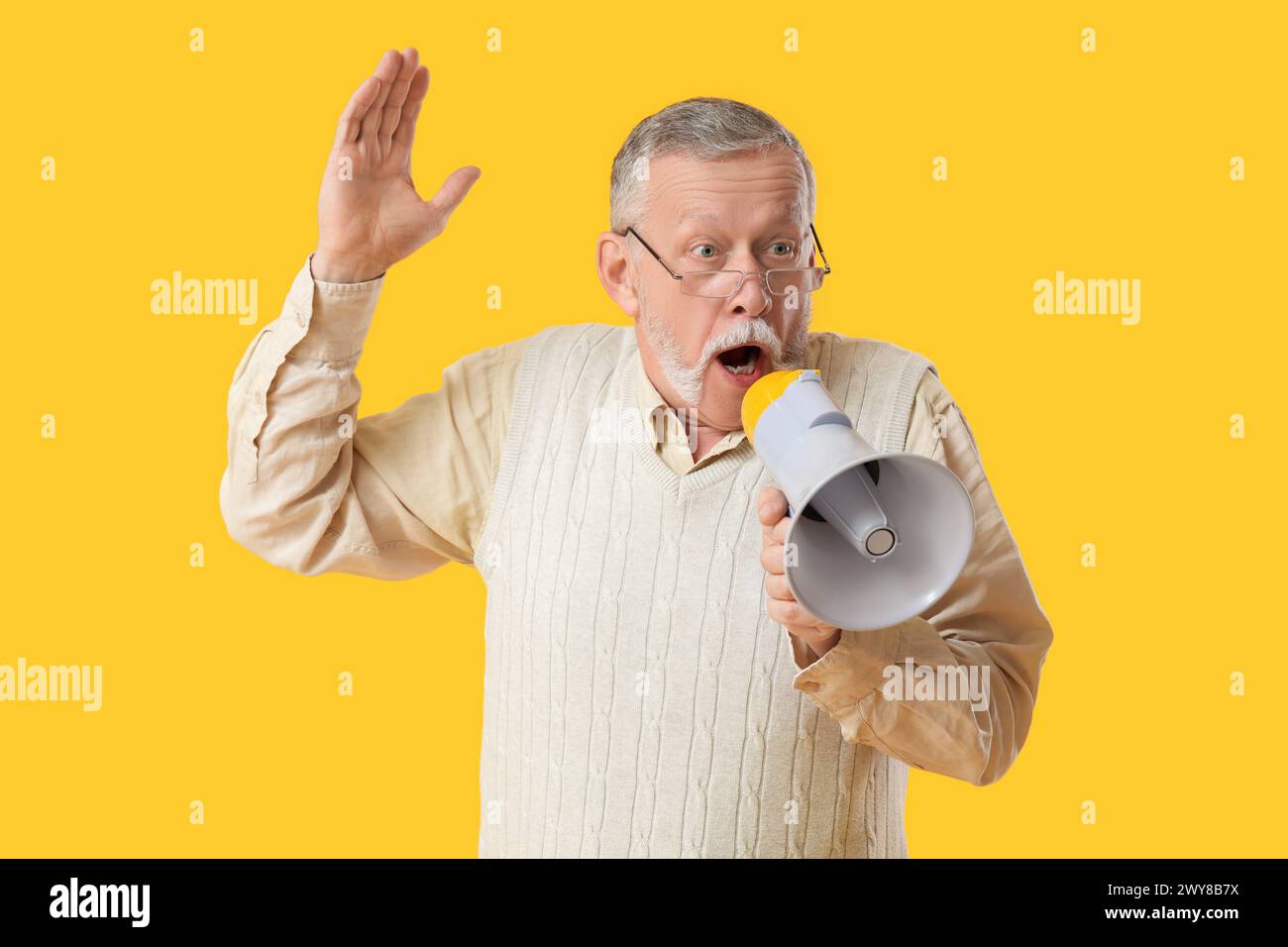 Shocked senior man with megaphone on yellow background Stock Photo - Alamy