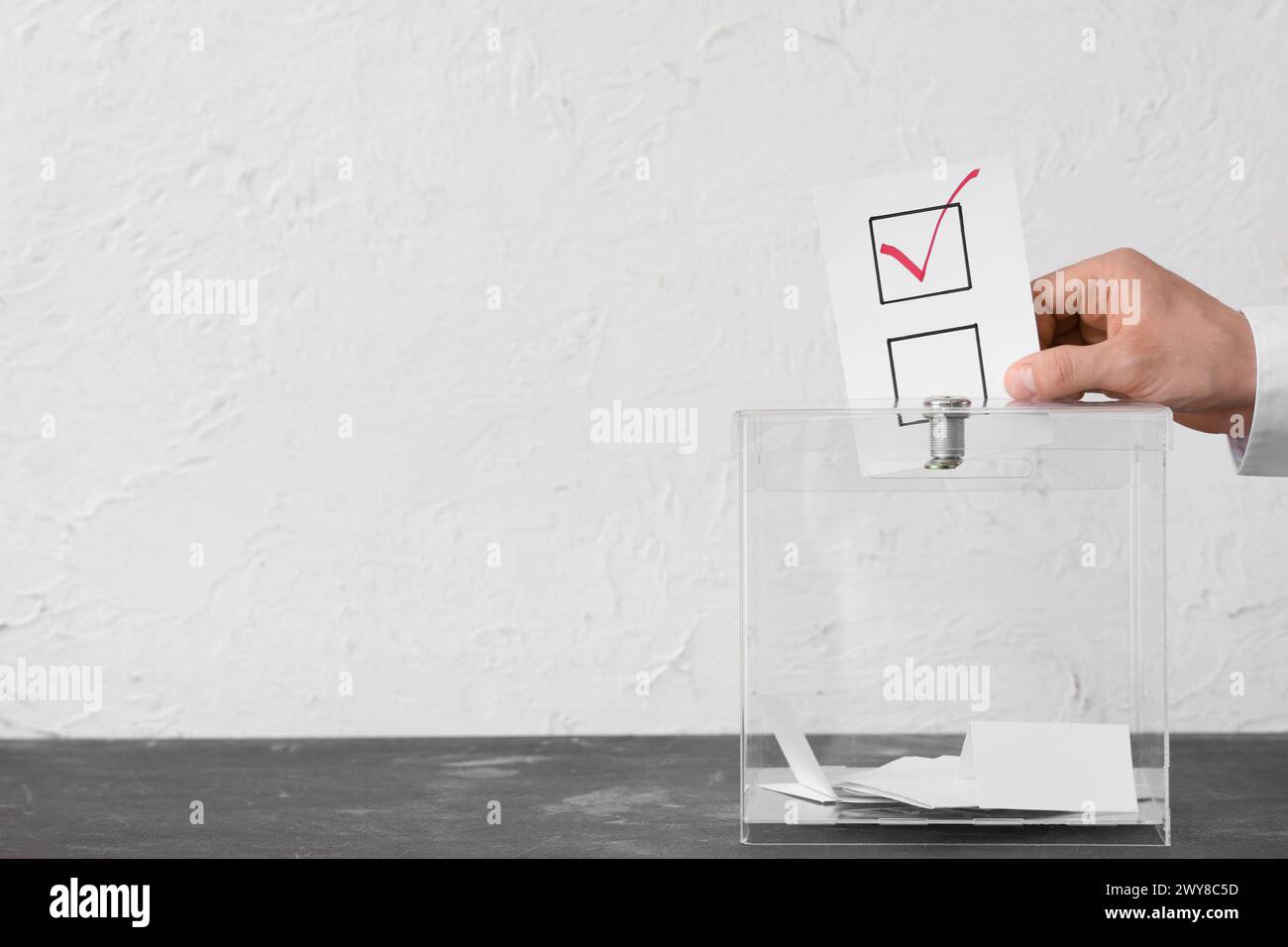 Voting man near ballot box on table against white background Stock ...