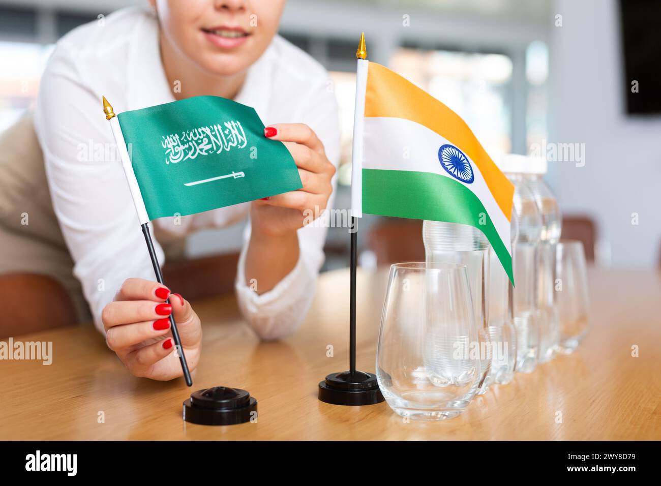 Unrecognizable girl sets midget flags of India and Saudi Arabia before ...