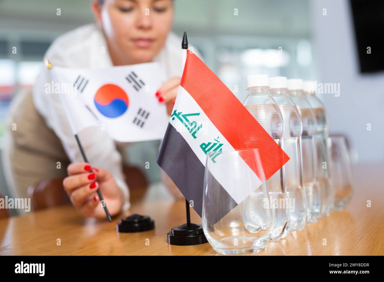 Unrecognizable girl sets midget flags of Iraq and South Korea before ...