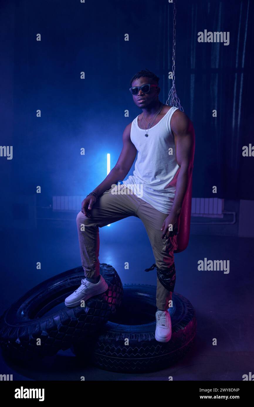 Fashion muscular rapper standing in neon lights of cool nightclub Stock ...