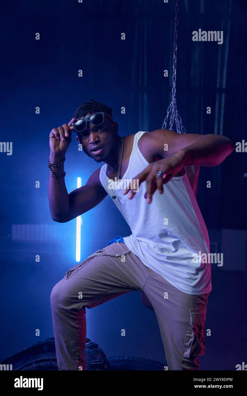 Fashion muscular rapper standing in neon lights of cool nightclub Stock ...