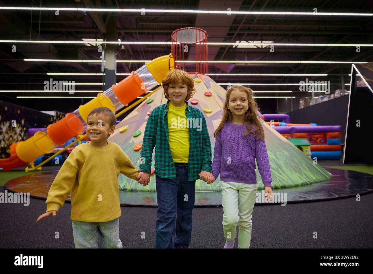 Happy preschool children having fun in play area standing in circle ...