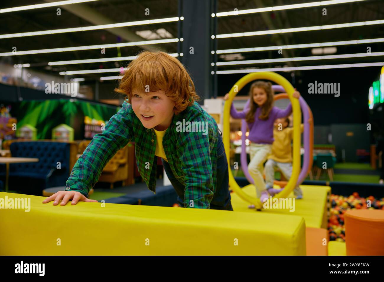 Happy children passing road of obstacles on indoor playground Stock ...