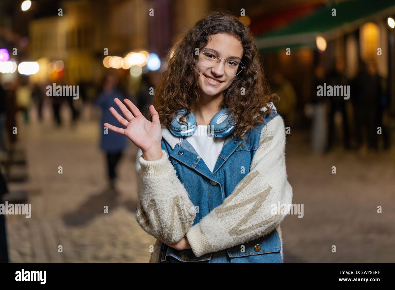Hello. Teenage girl in casual clothes smiling friendly at camera ...