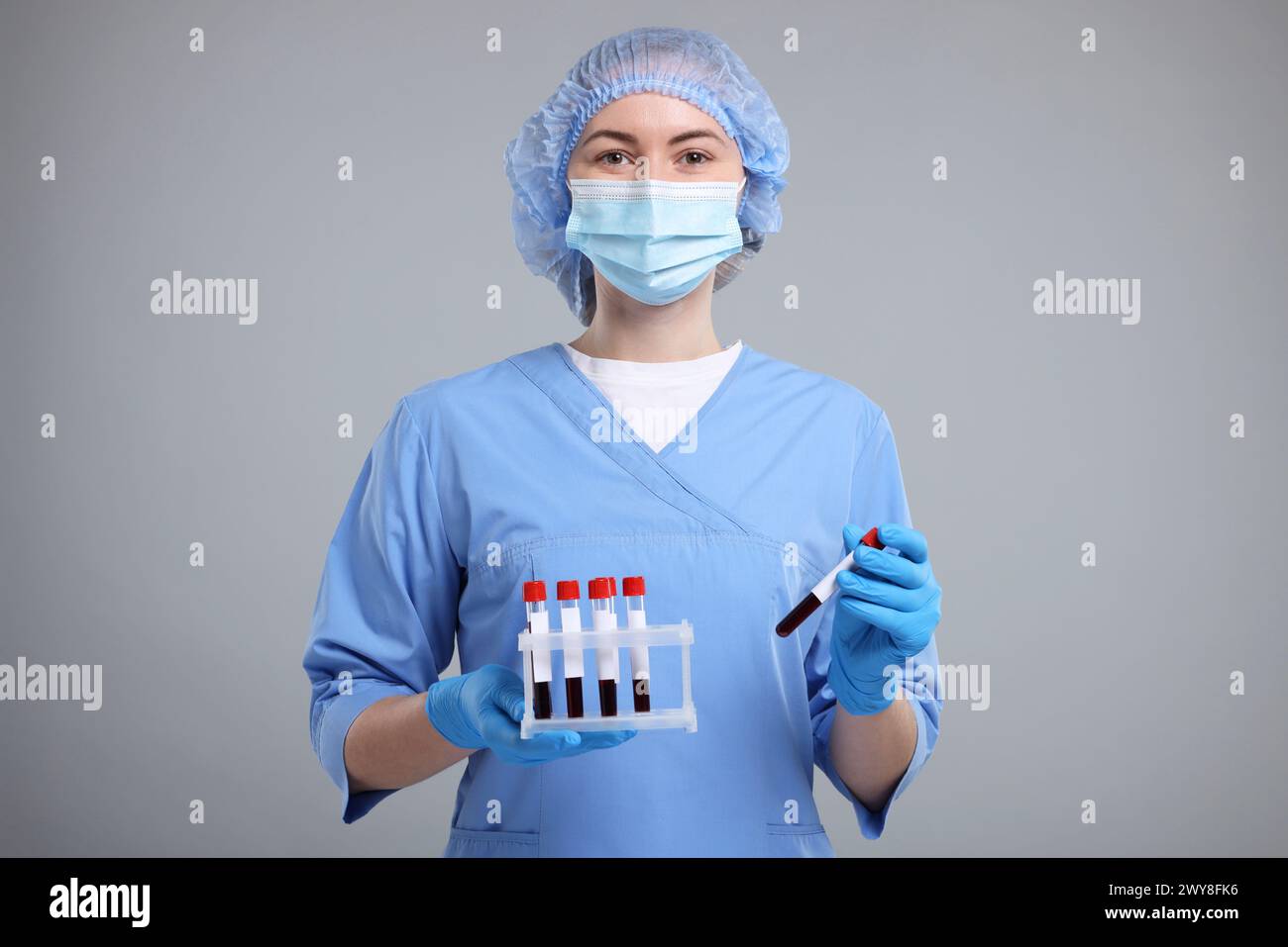 Laboratory testing. Doctor with blood samples in tubes on light grey ...