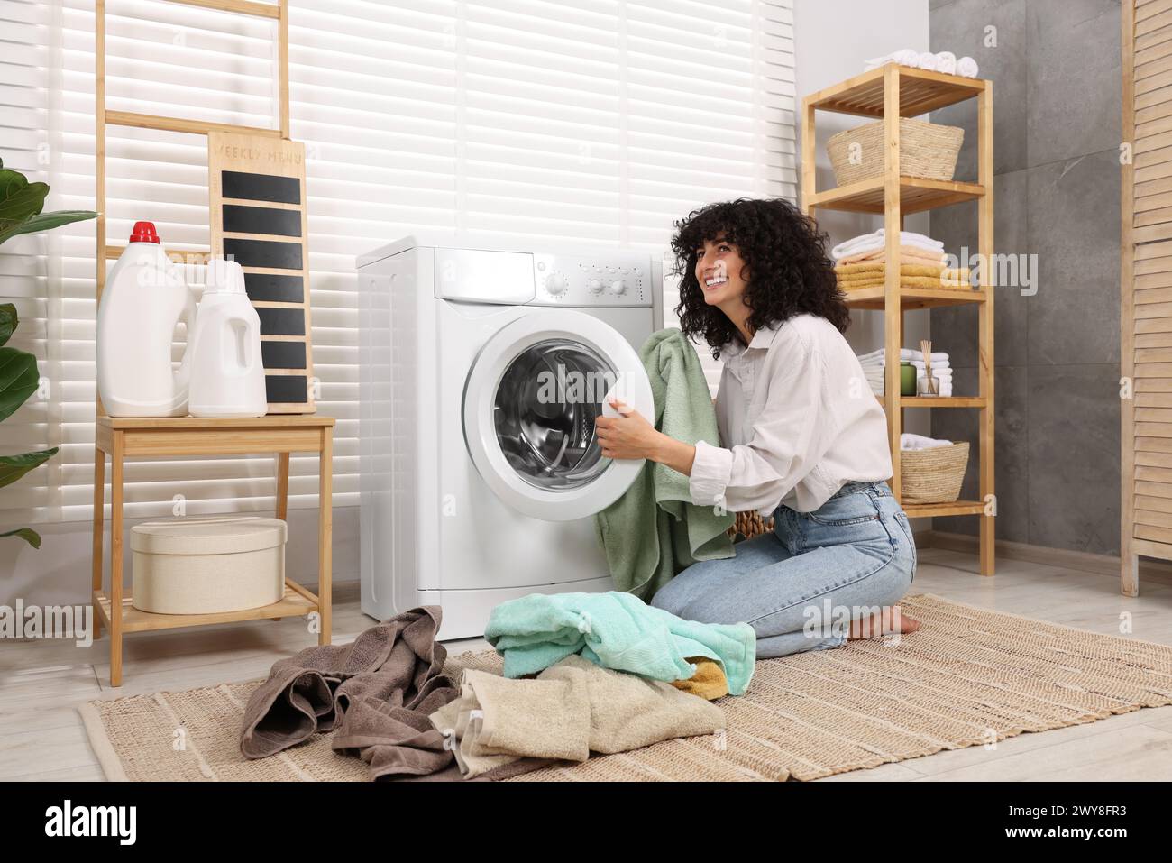 Woman putting laundry into washing machine indoors Stock Photo - Alamy