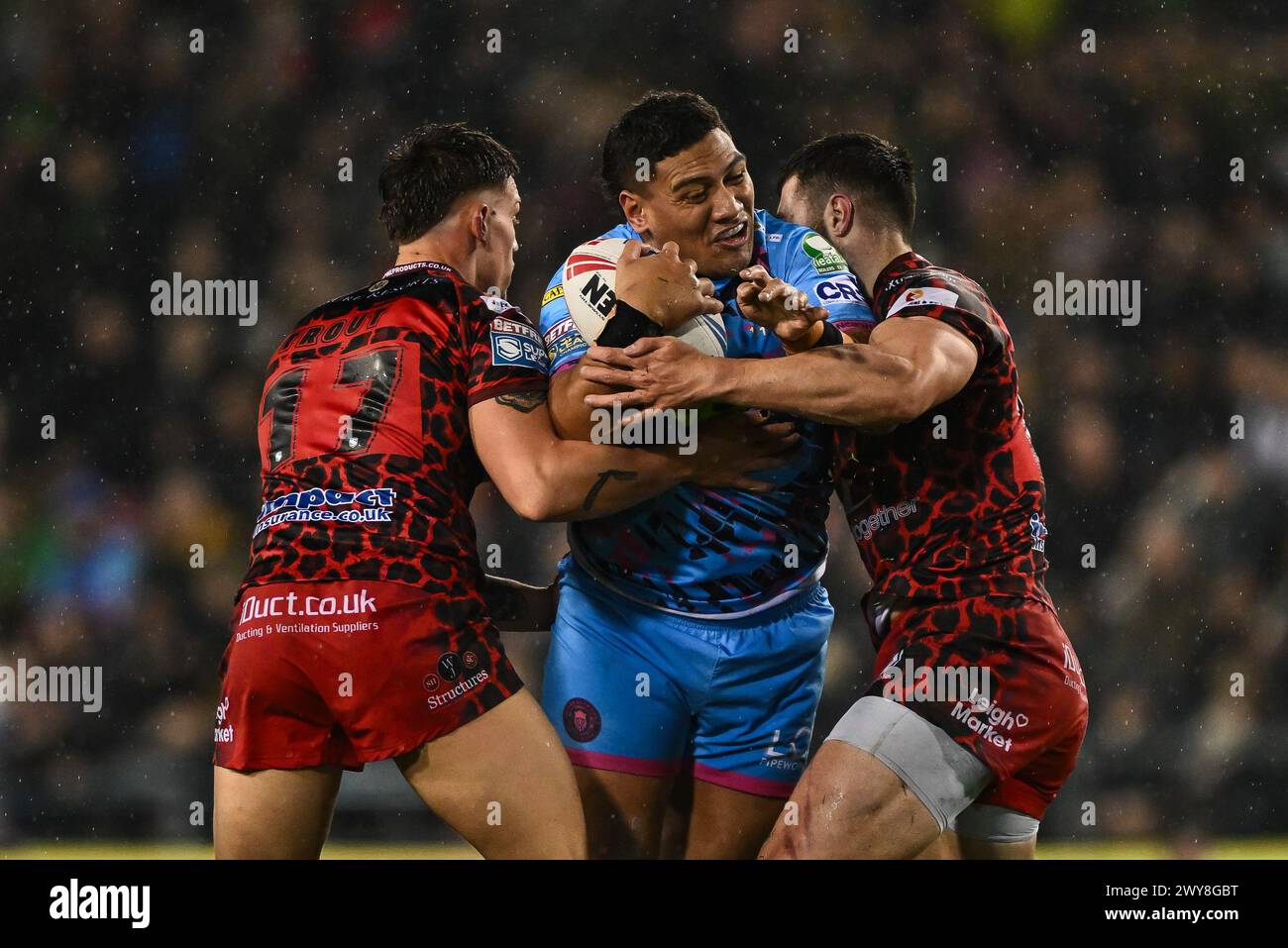Patrick Mago of Wigan Warriors is tackled by Owen Trout of Leigh ...