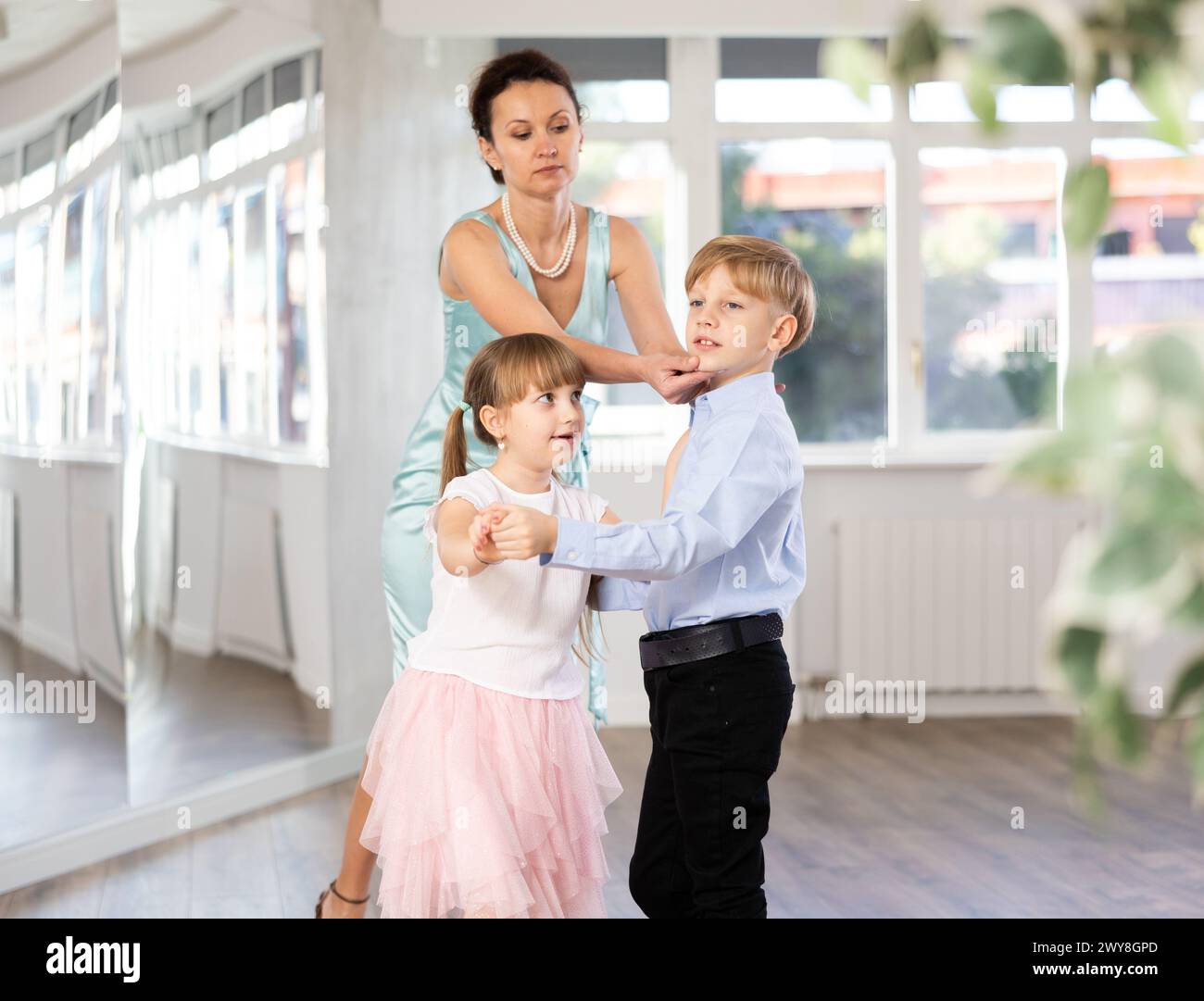 Teacher rearrange dancers pose during pair ballroom dancing lesson ...