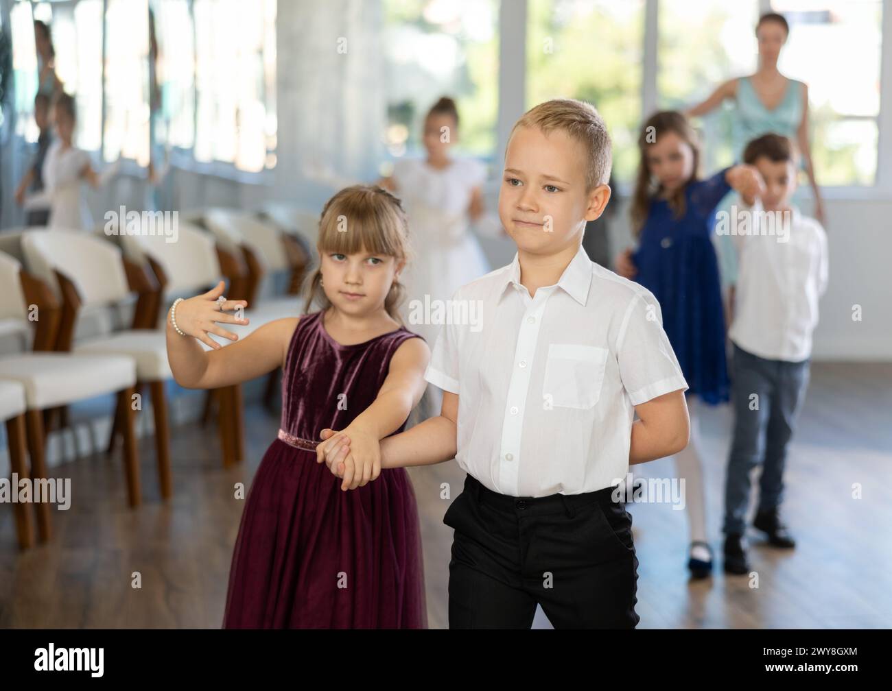 Preteen children practicing ballroom dances in pairs during dancing ...