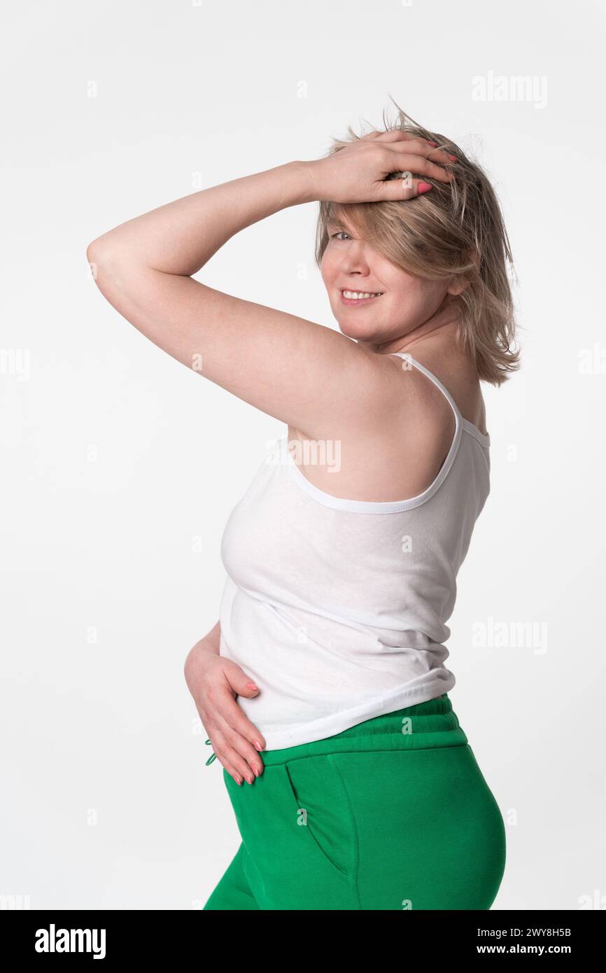 Portrait of happy plump woman is smiling and looking over her shoulder ...