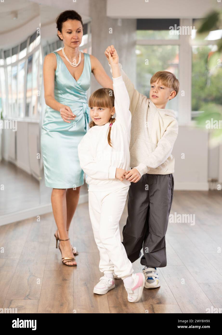Teacher rearrange dancers pose during pair ballroom dancing lesson ...