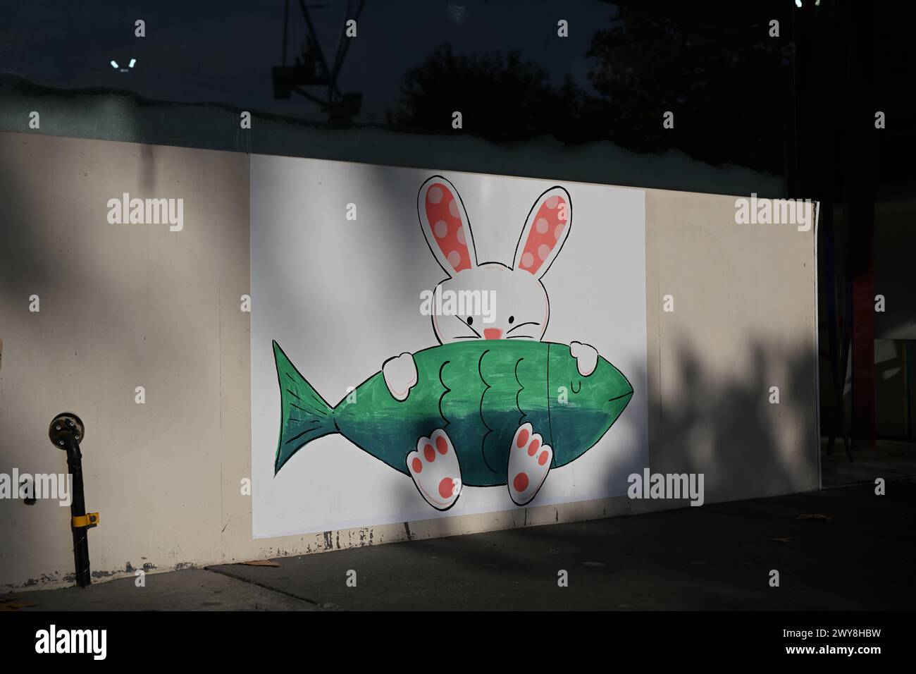 Cute Easter-themed drawing of a rabbit, or bunny, holding a fish on its ...