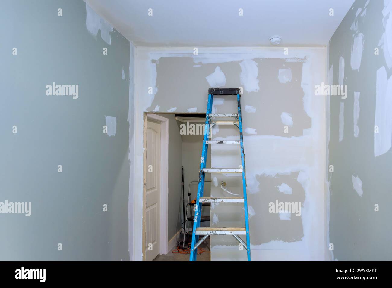 As part of home renovation project, plasterboard mounting is screwed to ...