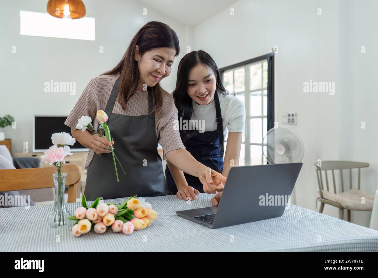 mother and daughter arrange flowers together as a hobby. mother and ...
