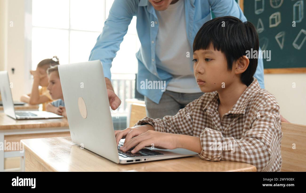 Caucasian teacher helping asian student coding engineering prompt while diverse student using ...
