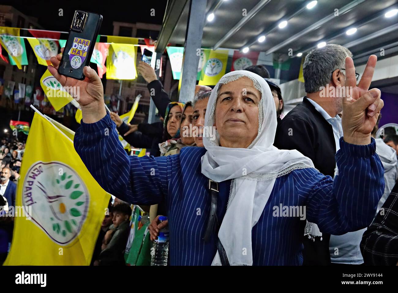 A Kurdish woman is seen making a victory sign with the flag of the ...