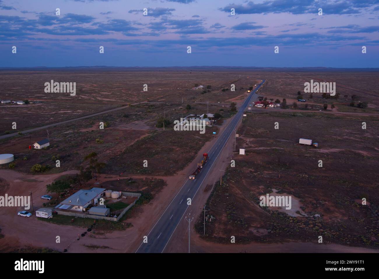Aerial view of a quiet road passing through a rural landscape at dusk ...