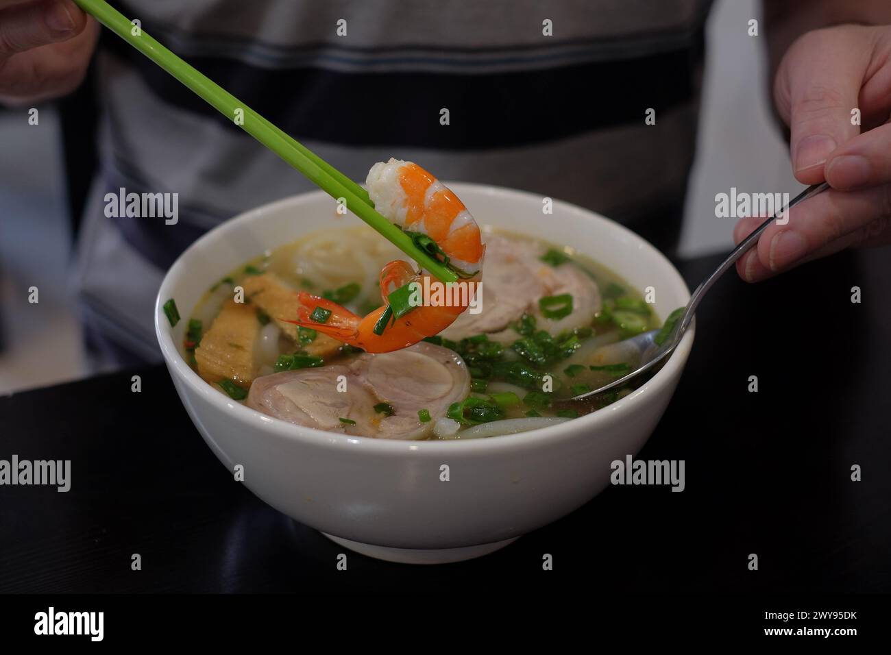 Man eating a bowl of Pho, Vietnamese noodle soup Prawns, Pork, Fish ...