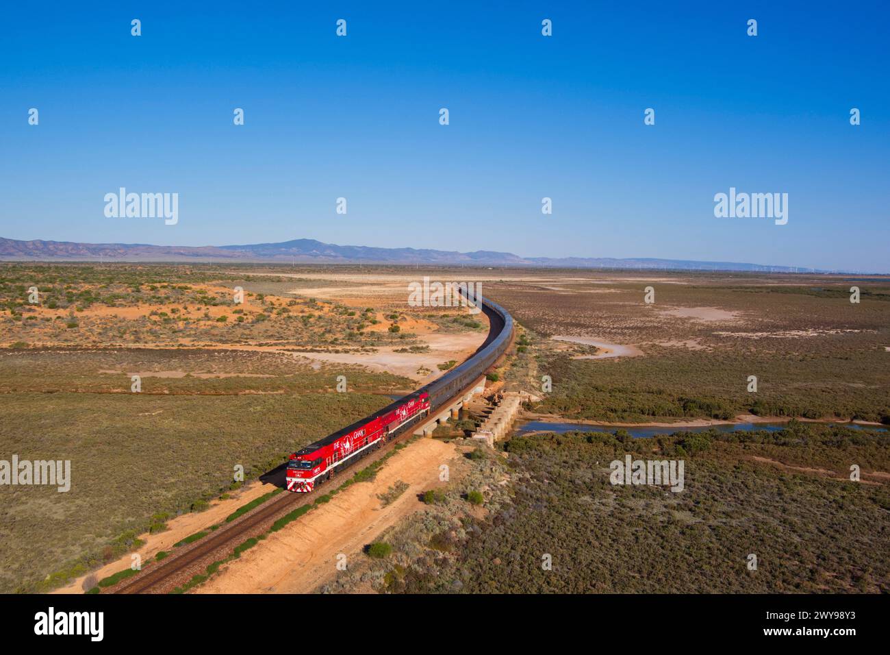 Aerial view of The Ghan a long passenger train traveling through a vast ...