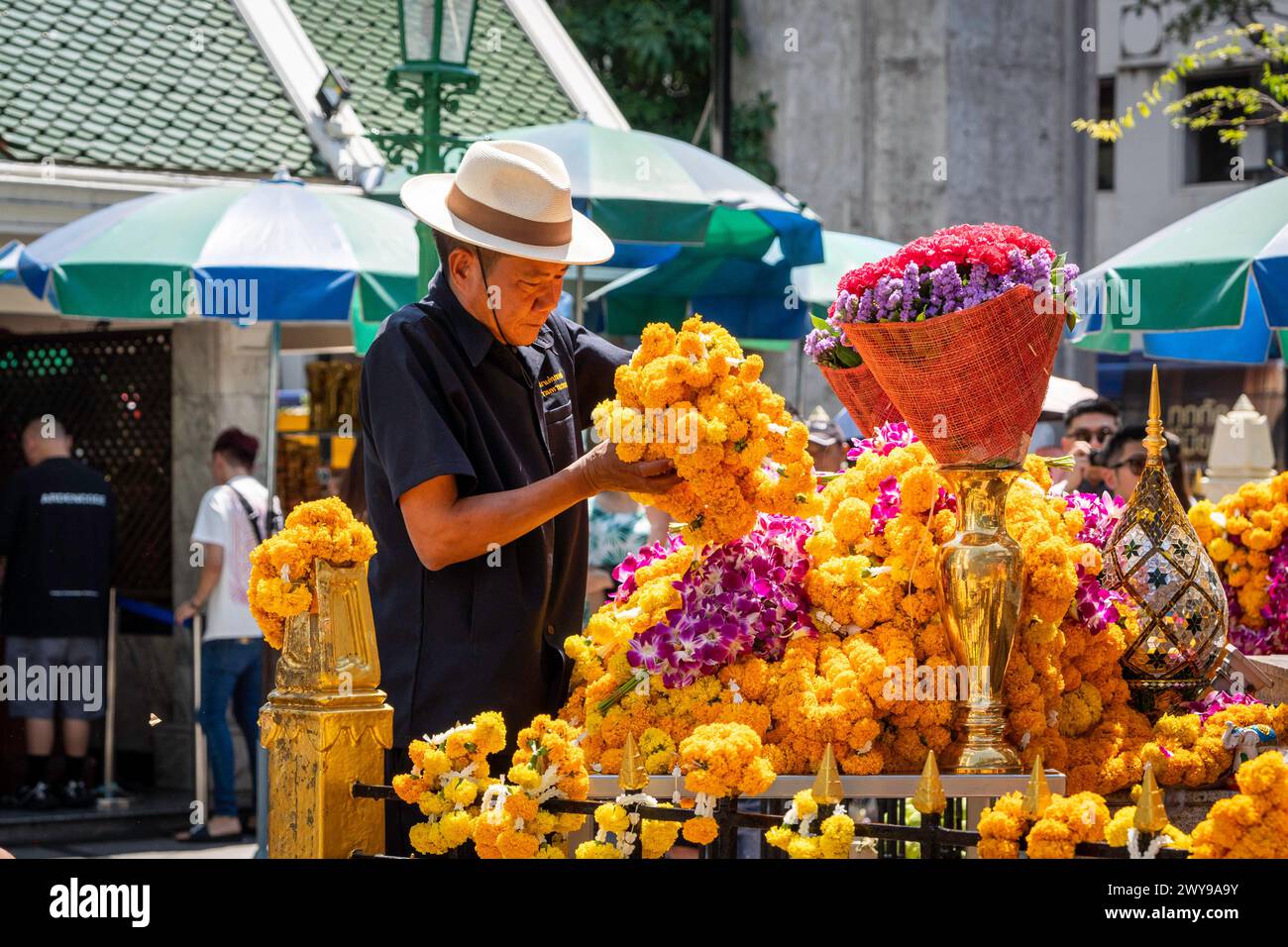 Staff from the shrine picking up flowers before putting them in the ...
