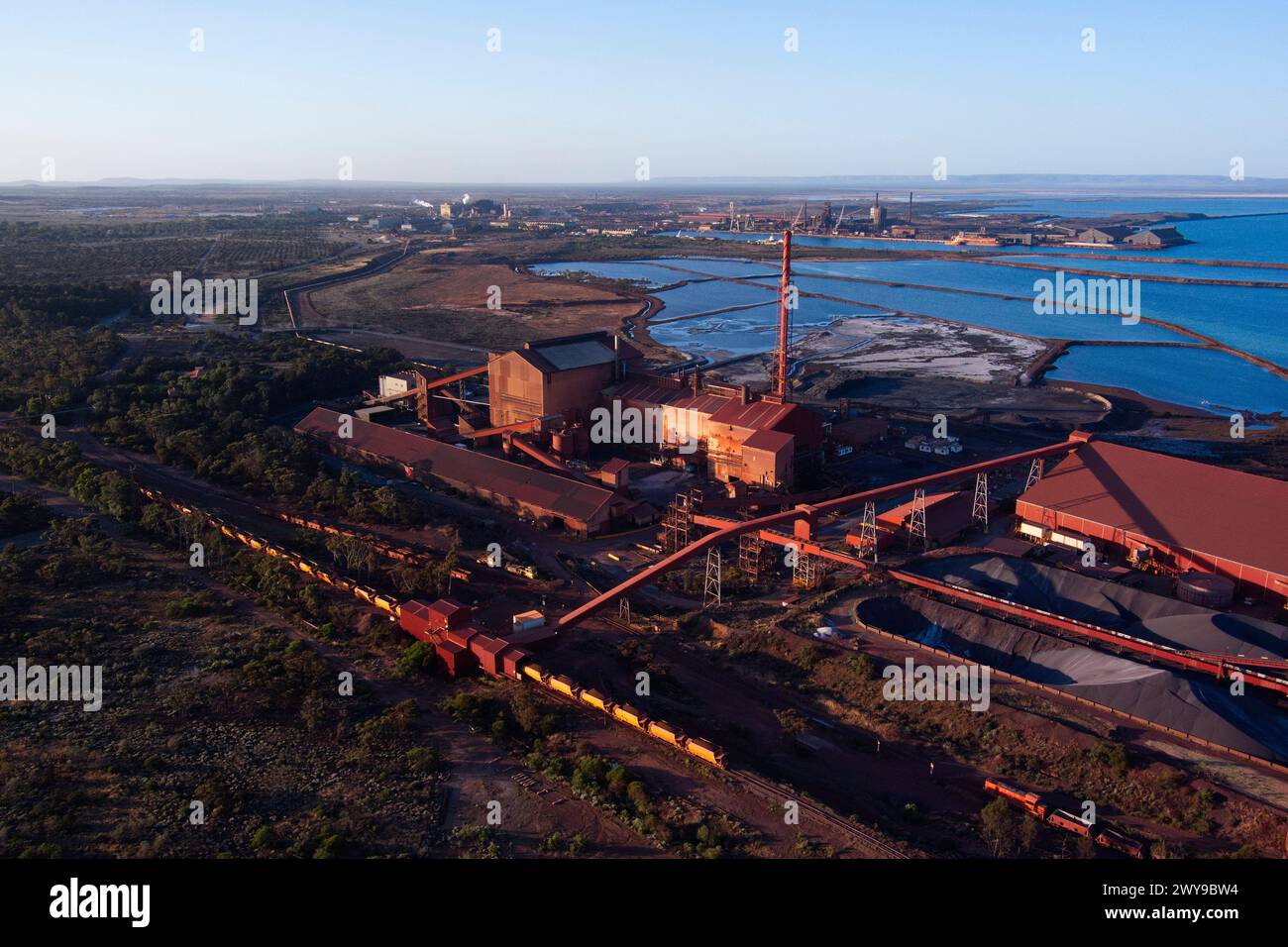 Aerial view of an industrial steel plant with infrastructure and ocean ...