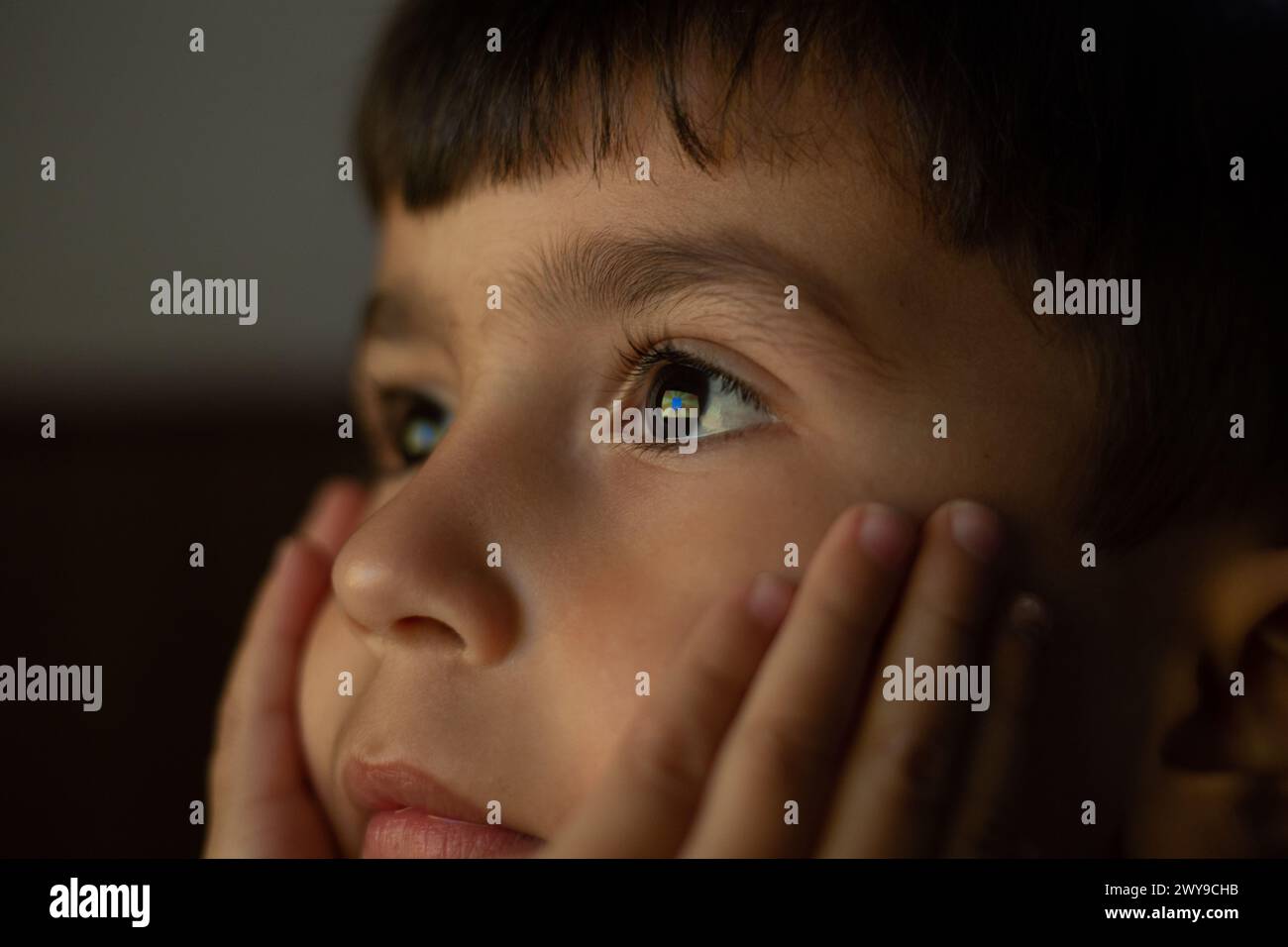 A concentrated child watching something on a screen Stock Photo - Alamy