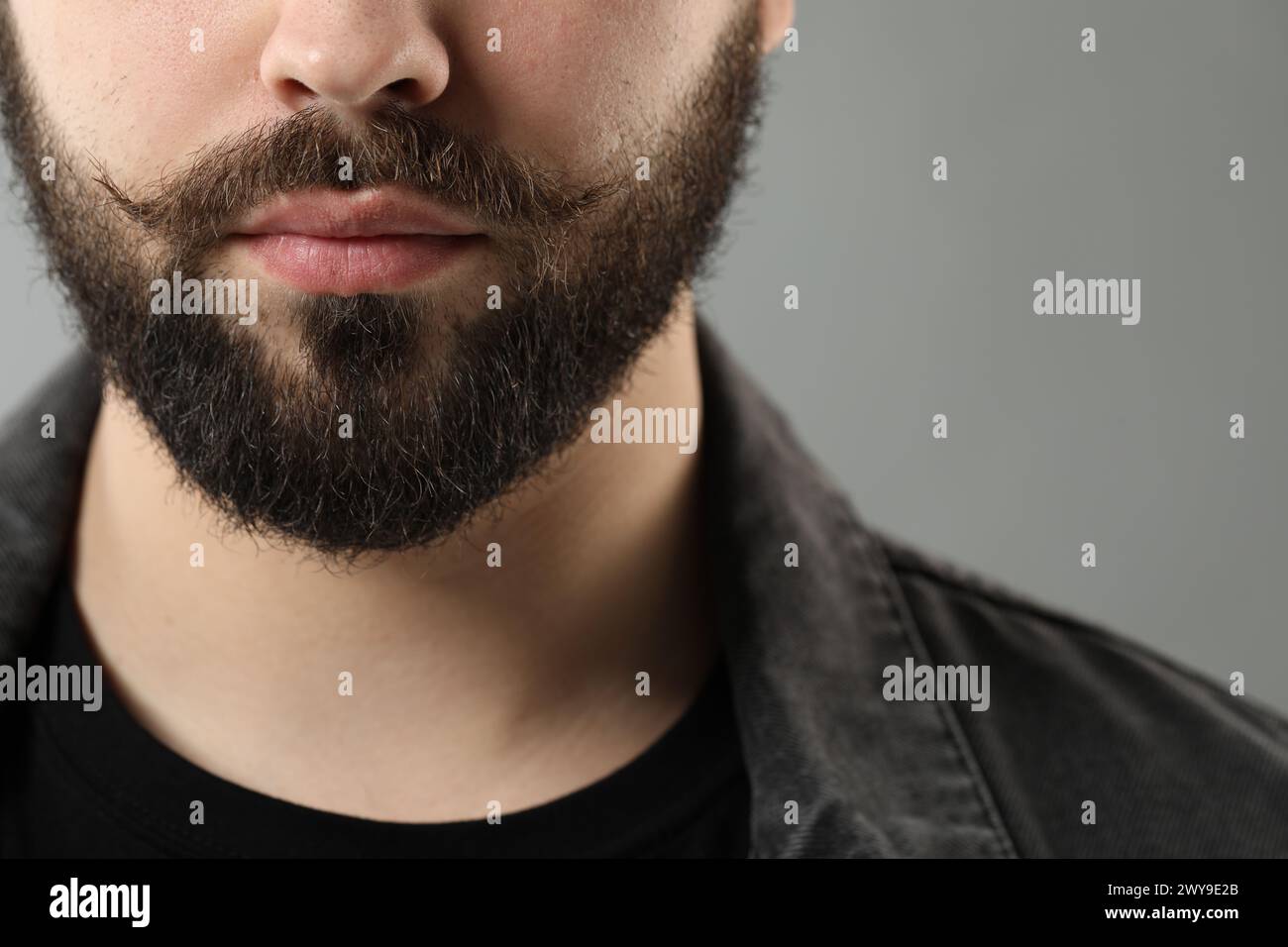 Handsome young man with mustache on grey background, closeup Stock ...