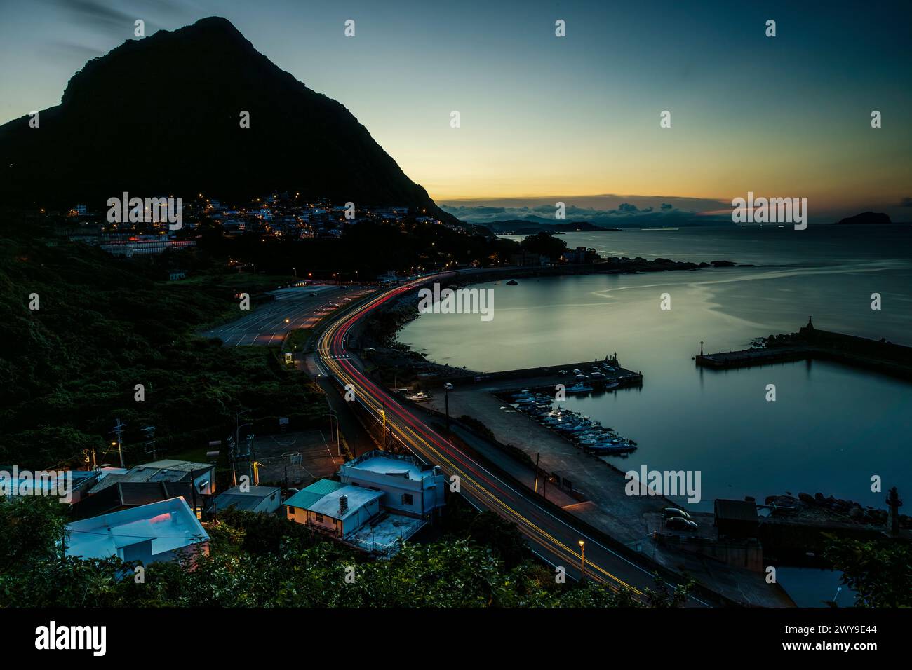 Light tracks of cars along a c-shaped section of coastal highway in ...