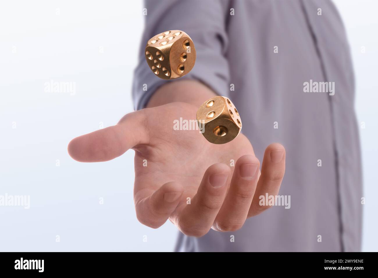 Man throwing golden dice on white background, closeup Stock Photo - Alamy