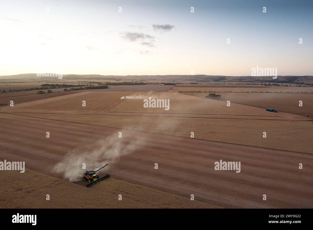 Aerial of combine harvesters working into the night to harvest wheat ...