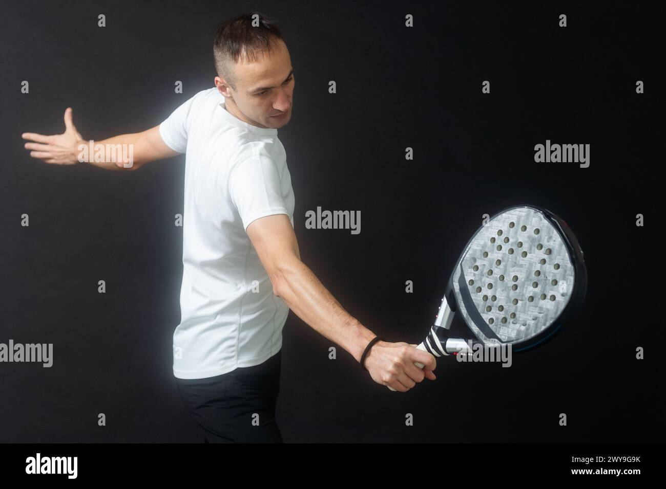 Portrait of man playing paddle tennis in position to hit a backhand ...