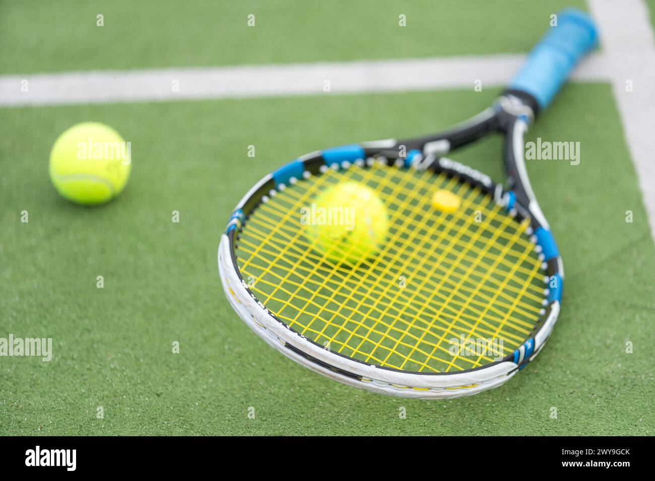Tennis racket and tennis ball besides the net on outdoor tennis court ...
